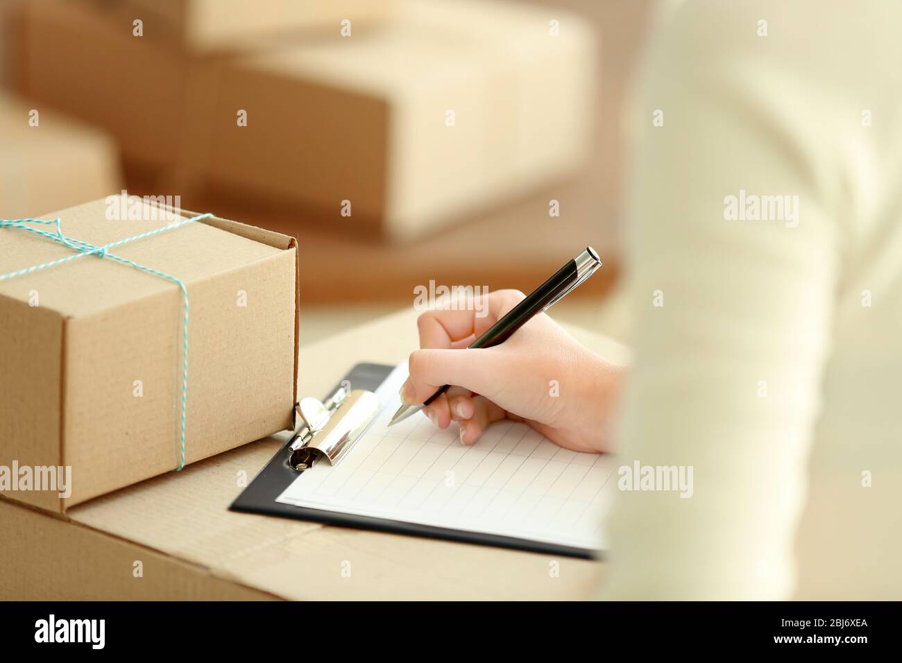 Delivery concept. Woman signs papers among parcels, close up Stock ...