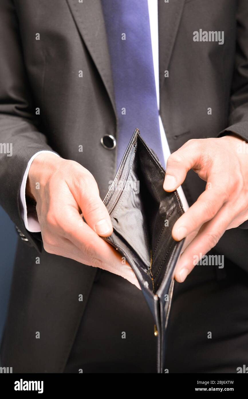 Man in a suit showing an empty purse Stock Photo - Alamy