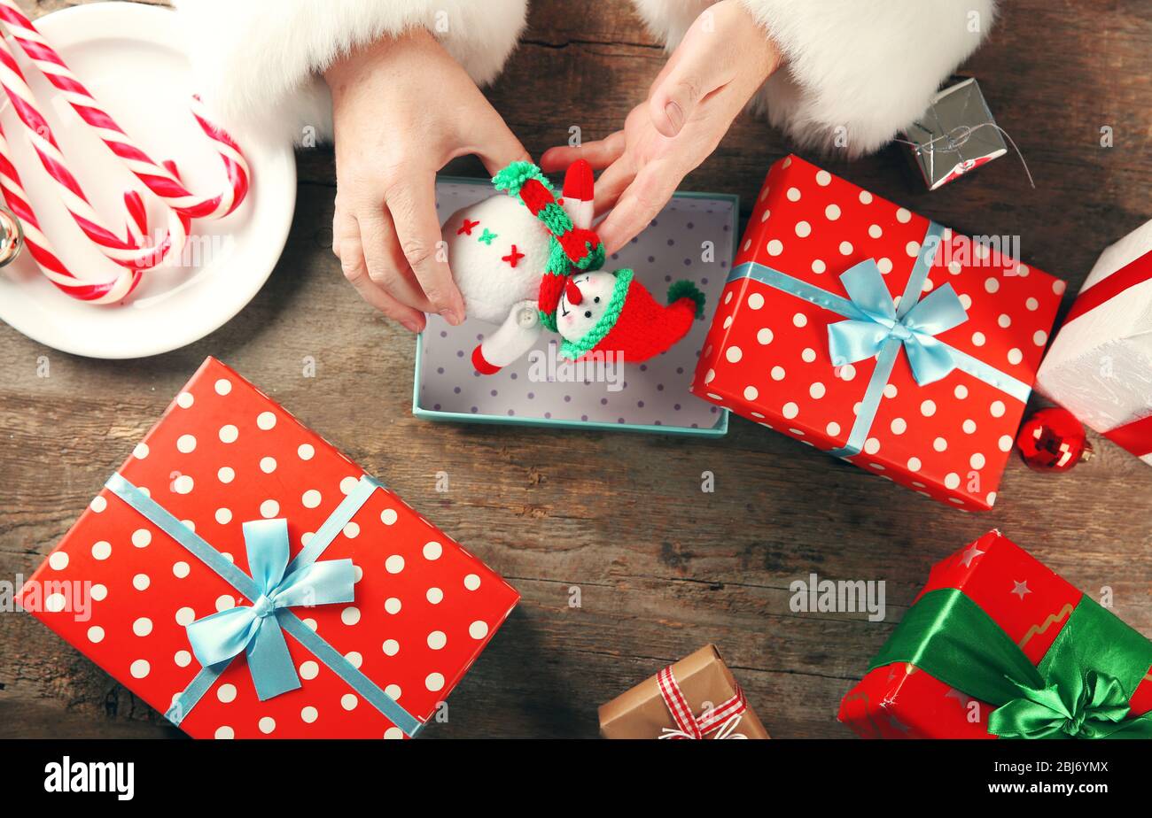 Santa Claus packing snowman toy into gift box, close up Stock Photo - Alamy