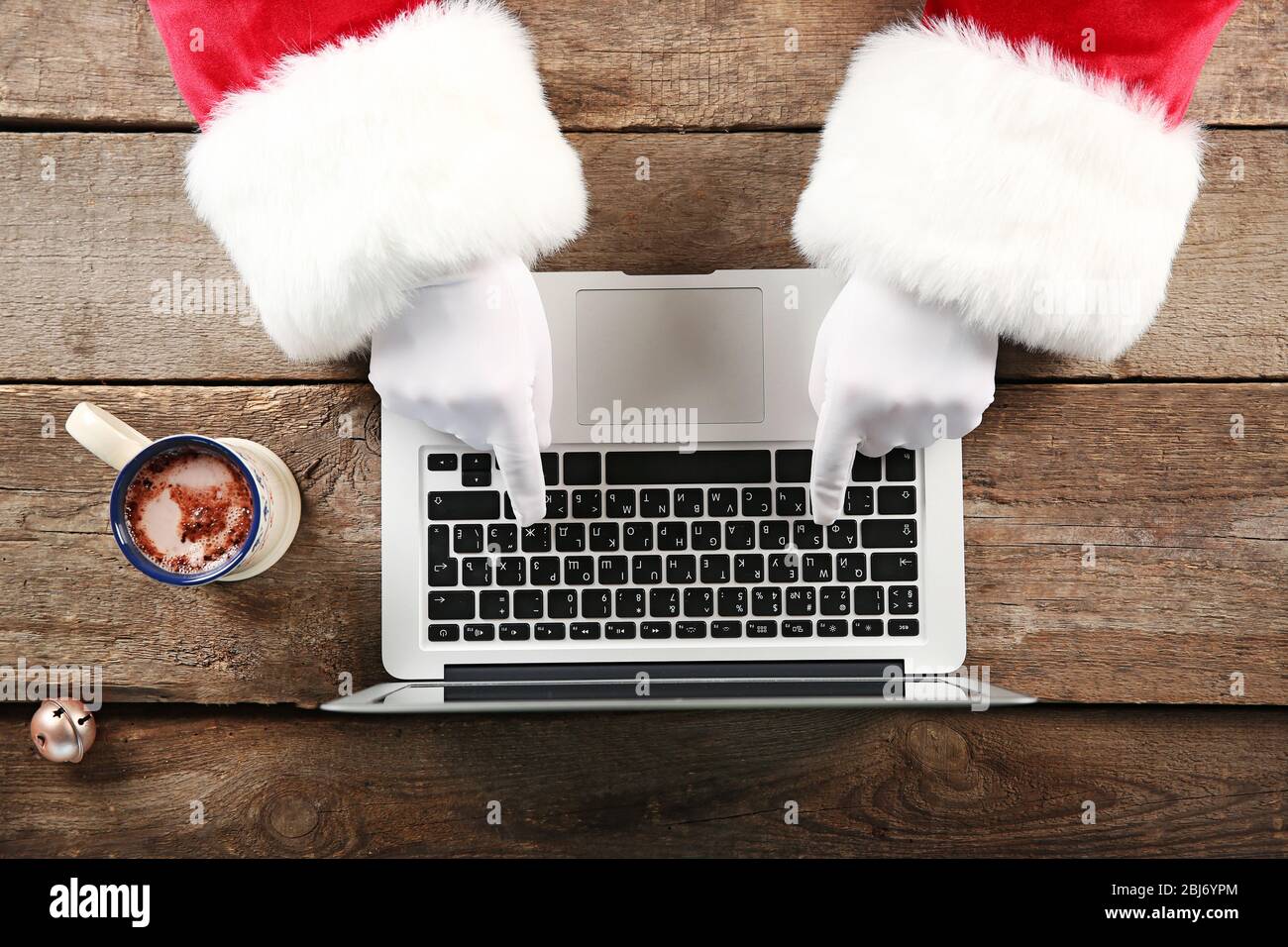 Santa hands typing on laptop on wooden table, close up Stock Photo - Alamy