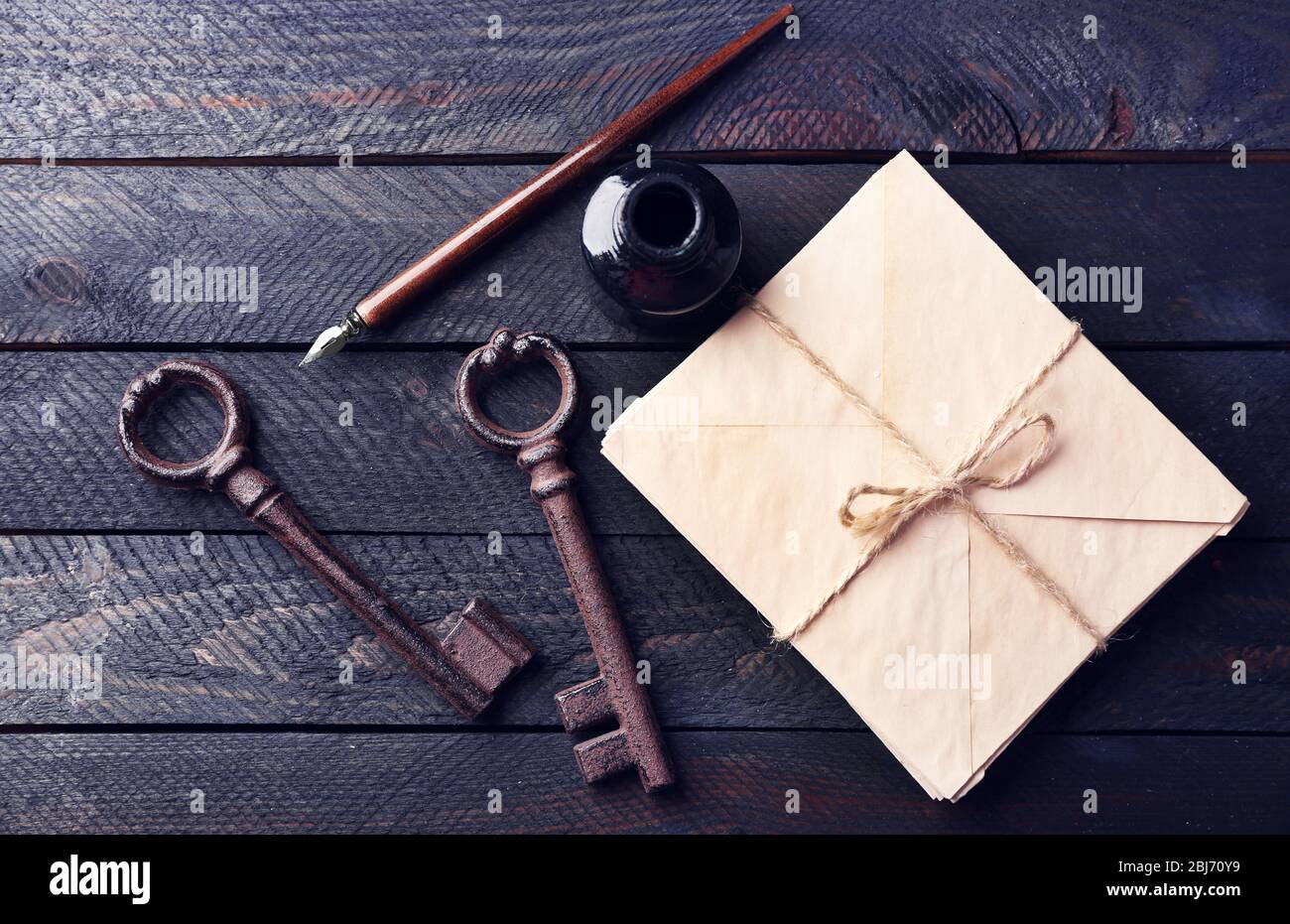 Old keys with papers, ink and pen on dark wooden background, close up ...