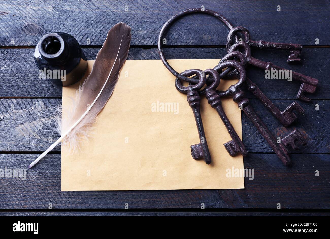 Bunch of old keys with paper, ink and pen on dark wooden background ...