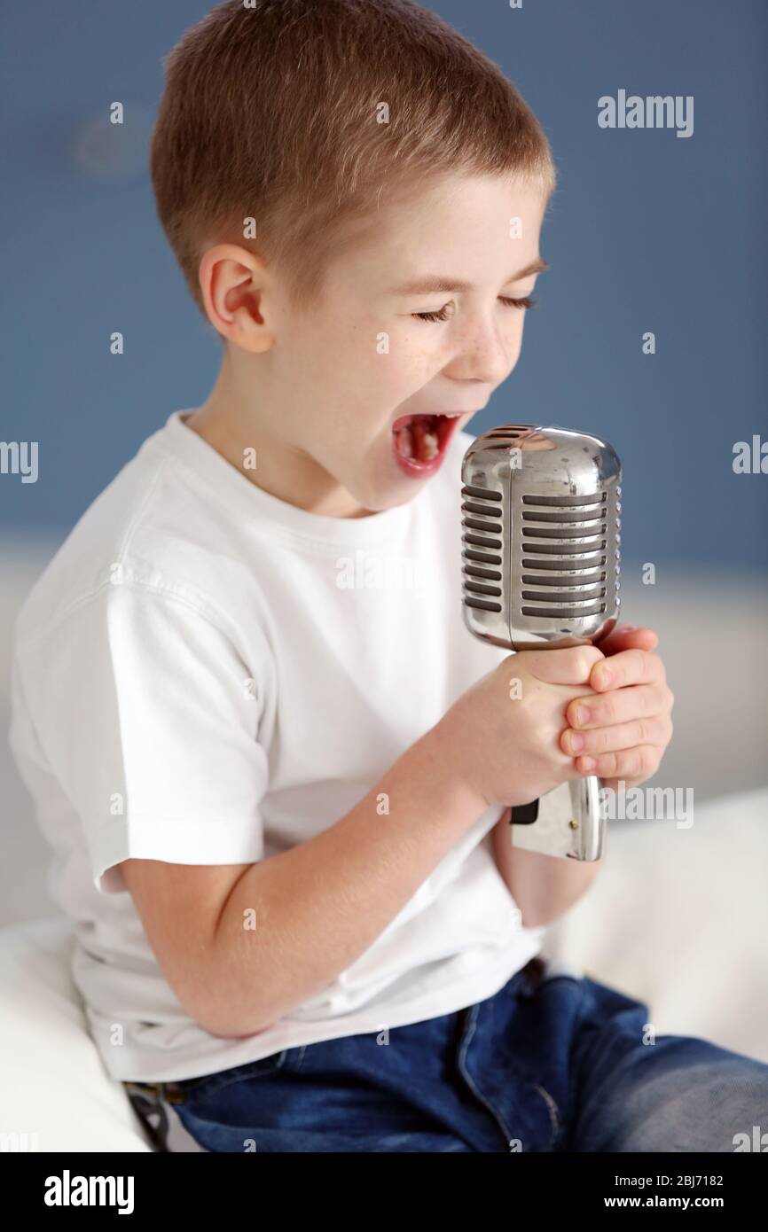 Little boy singing into the microphone at home Stock Photo - Alamy