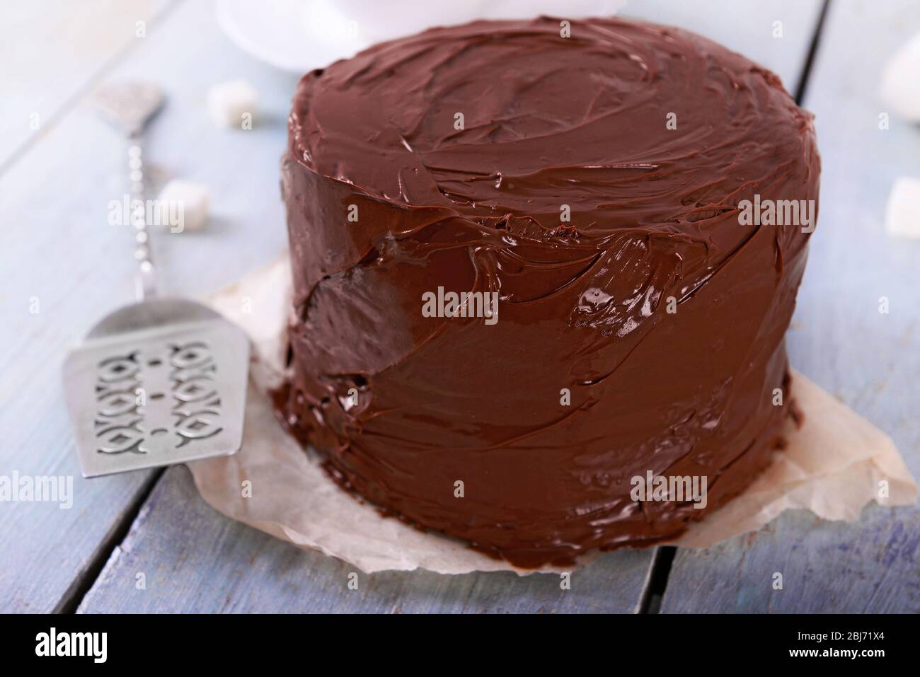 Chocolate cake with blade on a wooden table background Stock Photo - Alamy