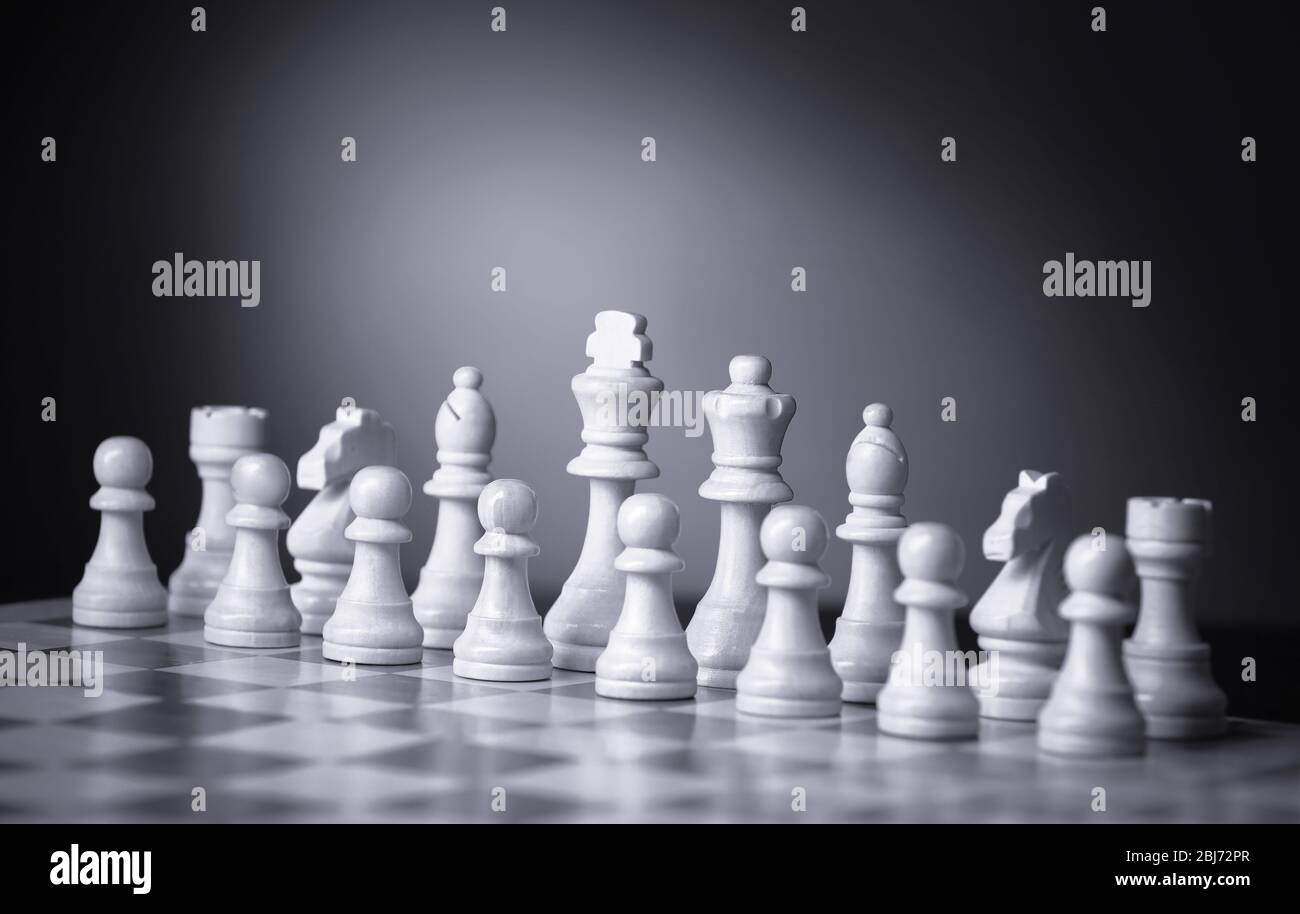 Chess pieces and game board on light green background Stock Photo - Alamy