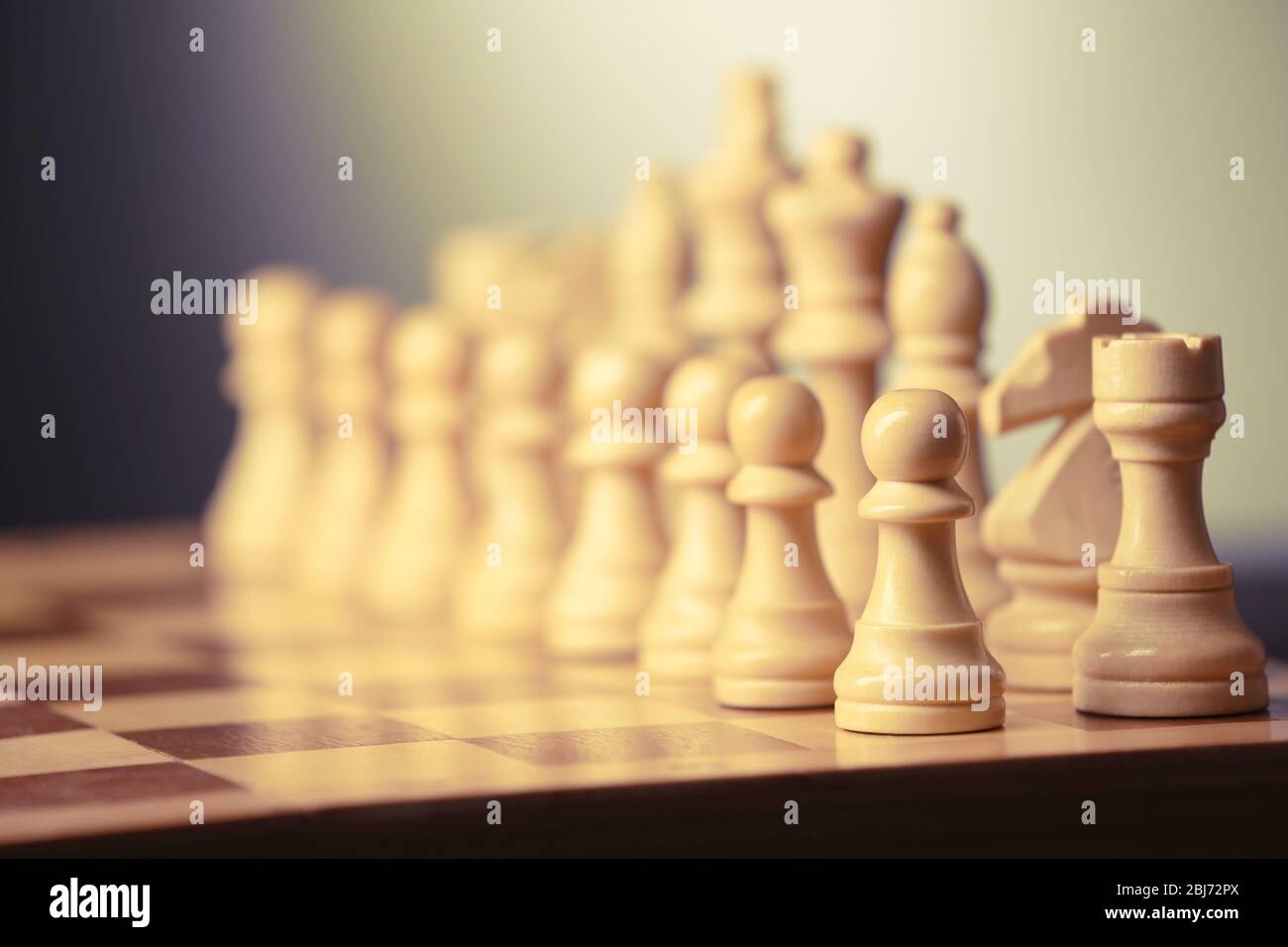 Chess pieces and game board on grey blurred background Stock Photo - Alamy