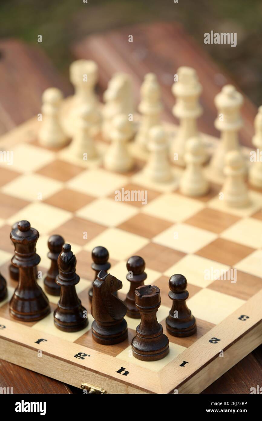 Chess pieces and game board on nature background Stock Photo - Alamy