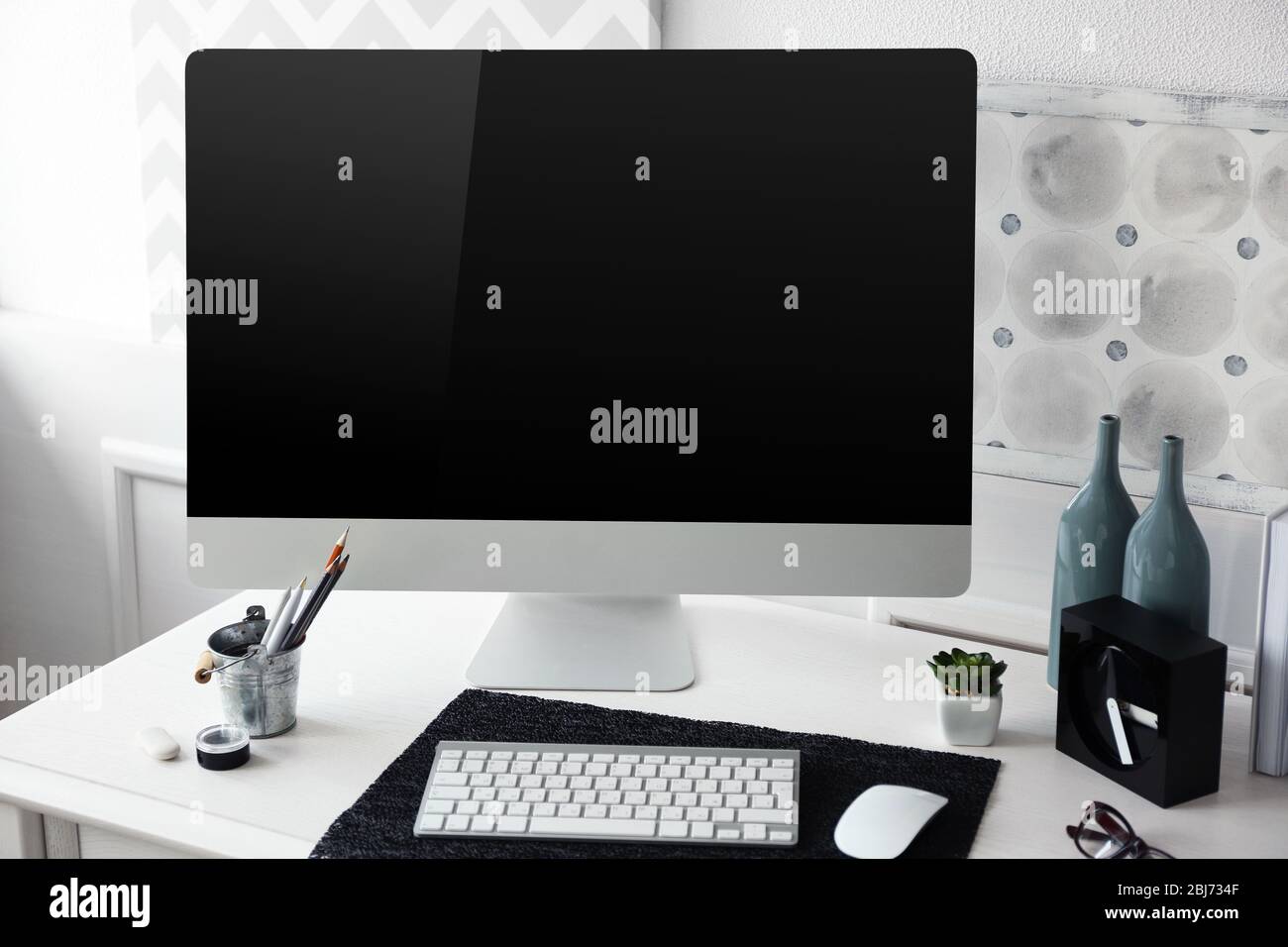 Modern wide screen monitor on white table in room interior Stock Photo ...