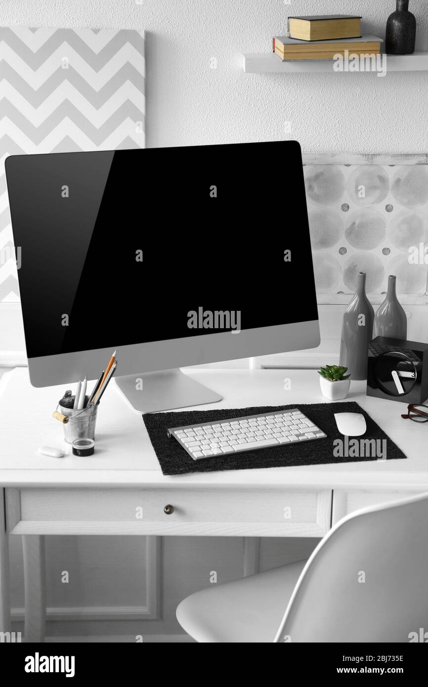 Modern wide screen monitor on white table in room interior Stock Photo ...