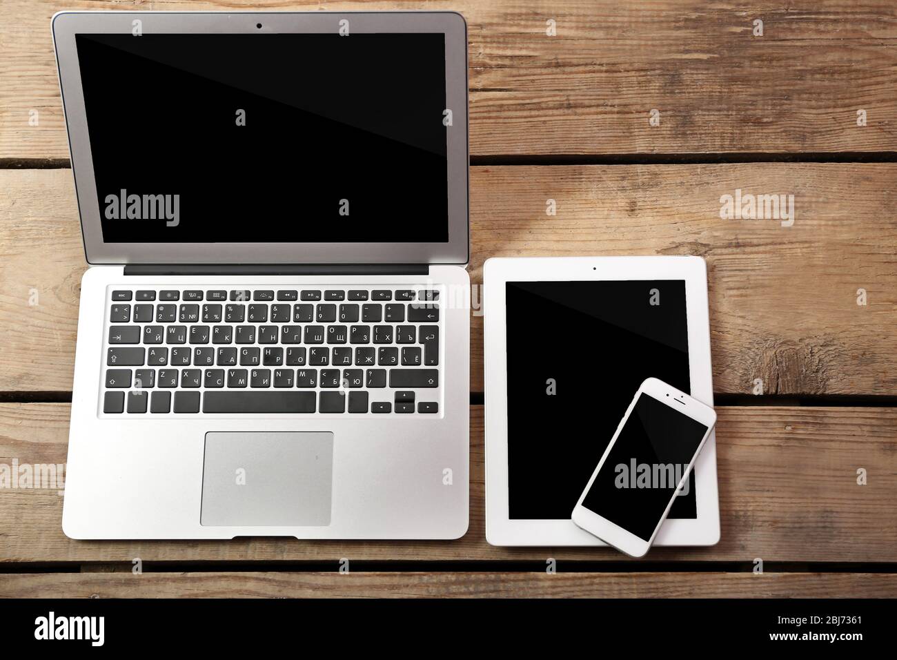 Different modern devices on wooden table Stock Photo - Alamy