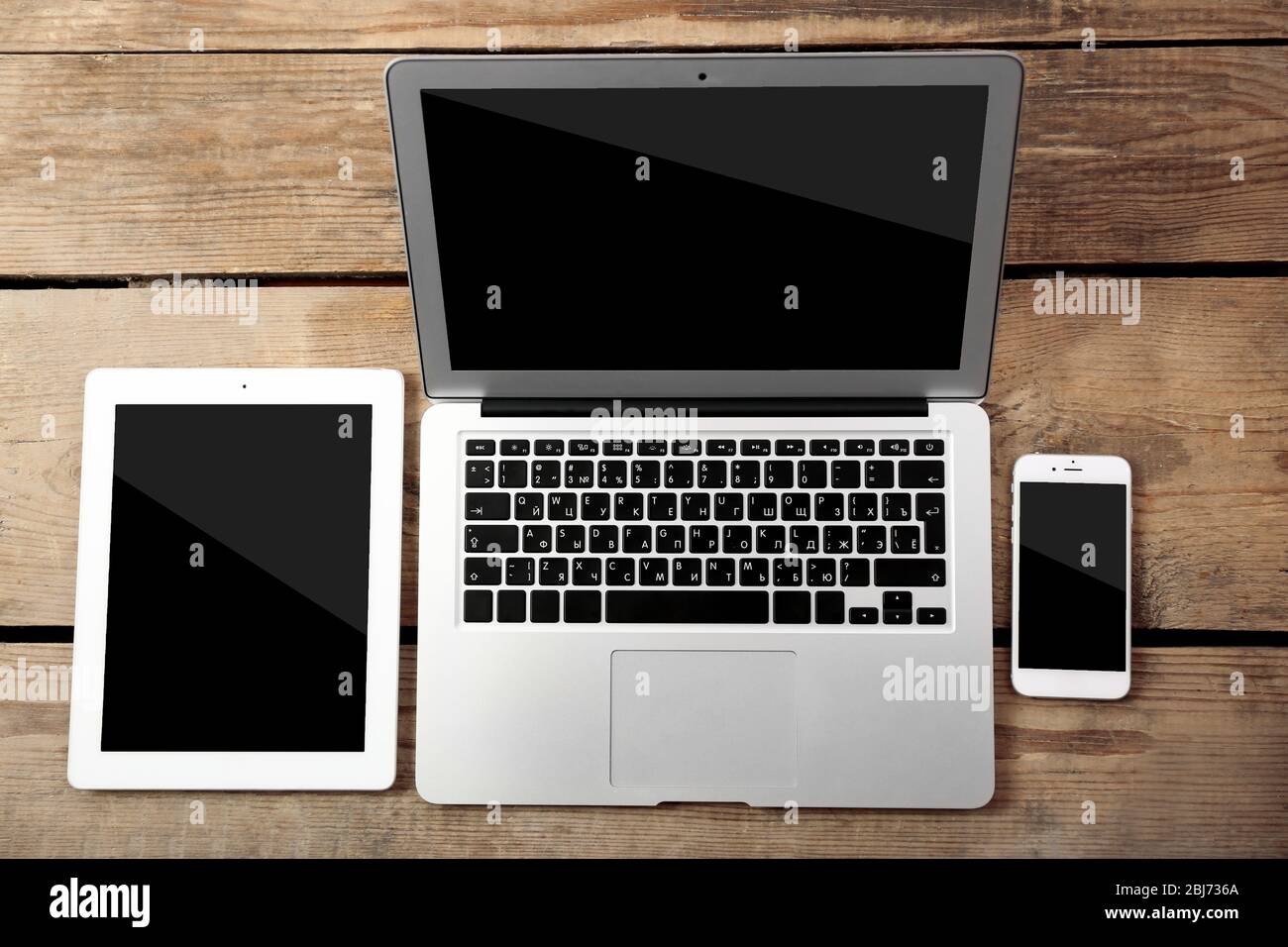 Different modern devices on wooden table Stock Photo - Alamy