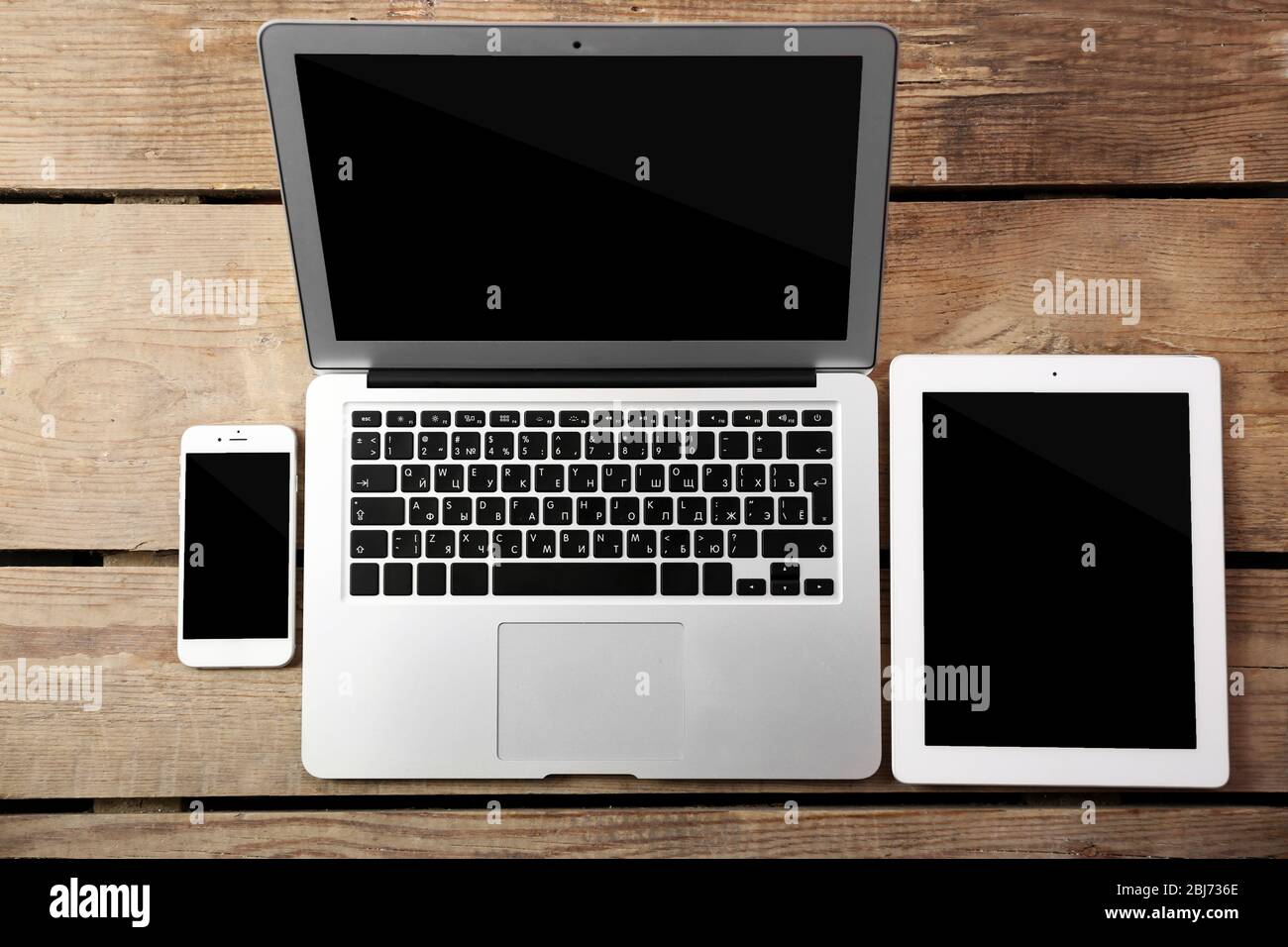 Different modern devices on wooden table Stock Photo - Alamy