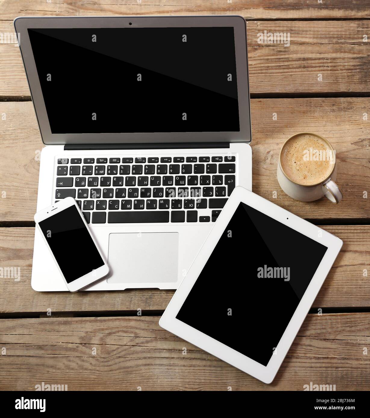 Different modern devices with cup of coffee on wooden table Stock Photo ...