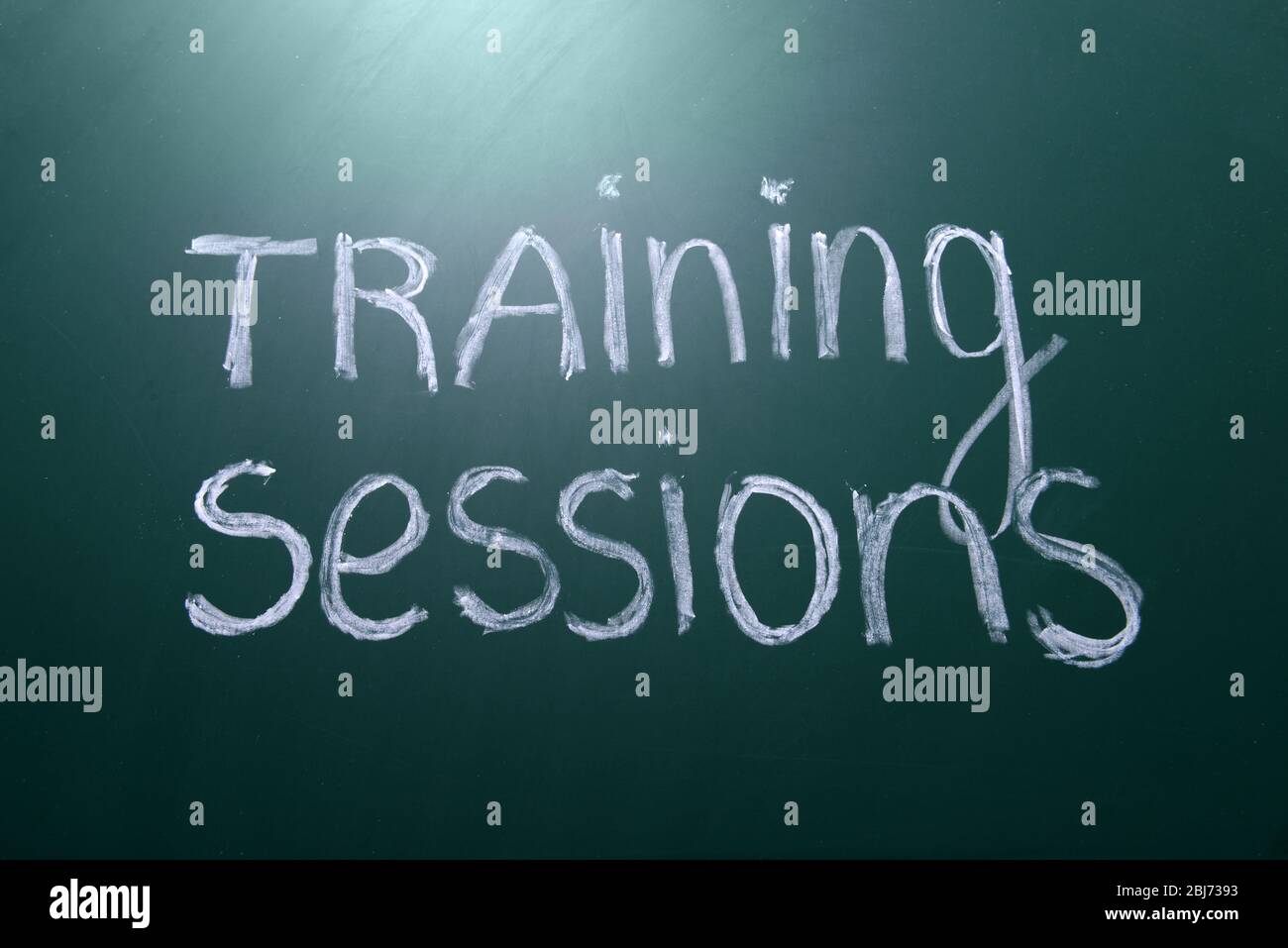 Training sessions inscription written with white chalk on blackboard ...