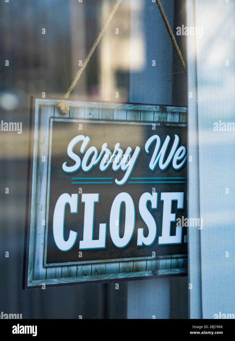 Closed sign hangs in window indicating business is not open to ...