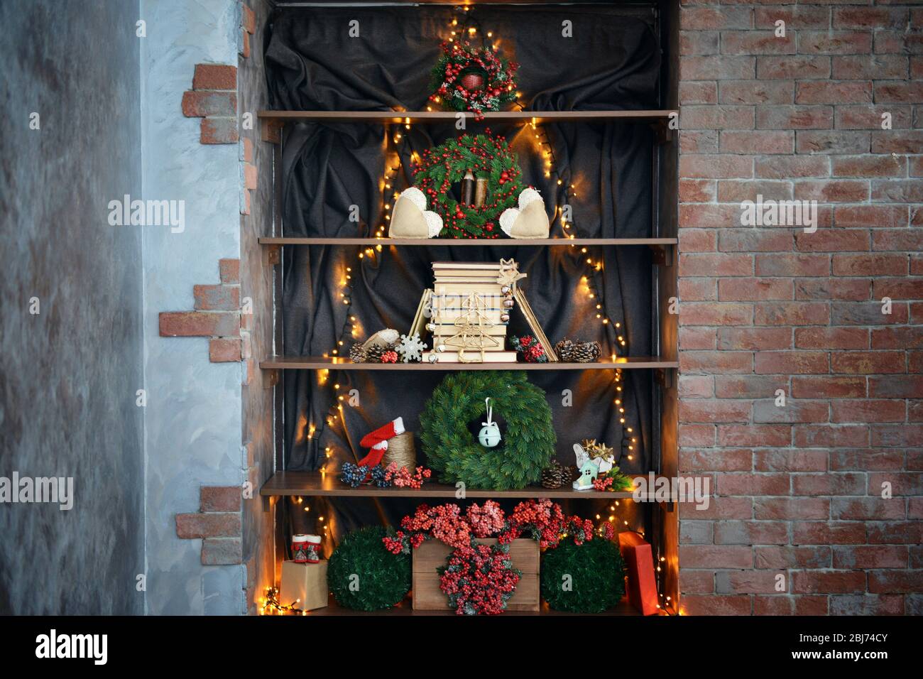 Christmas tree made of garland and other decor in bookcase Stock Photo ...