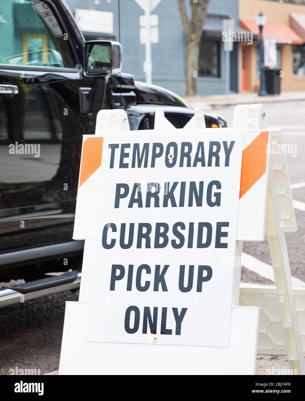 Temporary parking curbside pick up sign on a city street during daytime ...