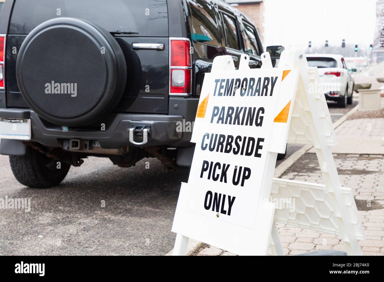 Temporary parking sign indicating curbside pick up only for vehicles on ...