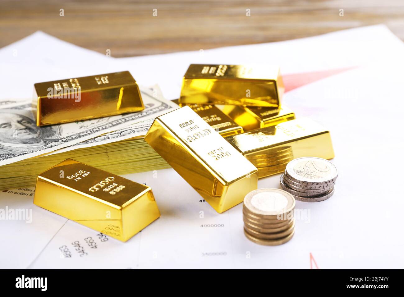 Gold bars with euro coins on paper background Stock Photo - Alamy