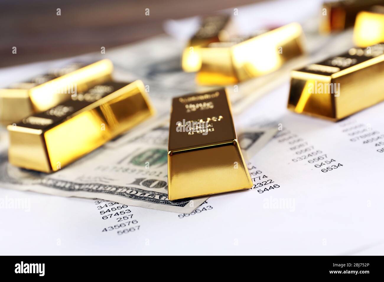 Gold bars with dollar banknotes on paper background Stock Photo - Alamy
