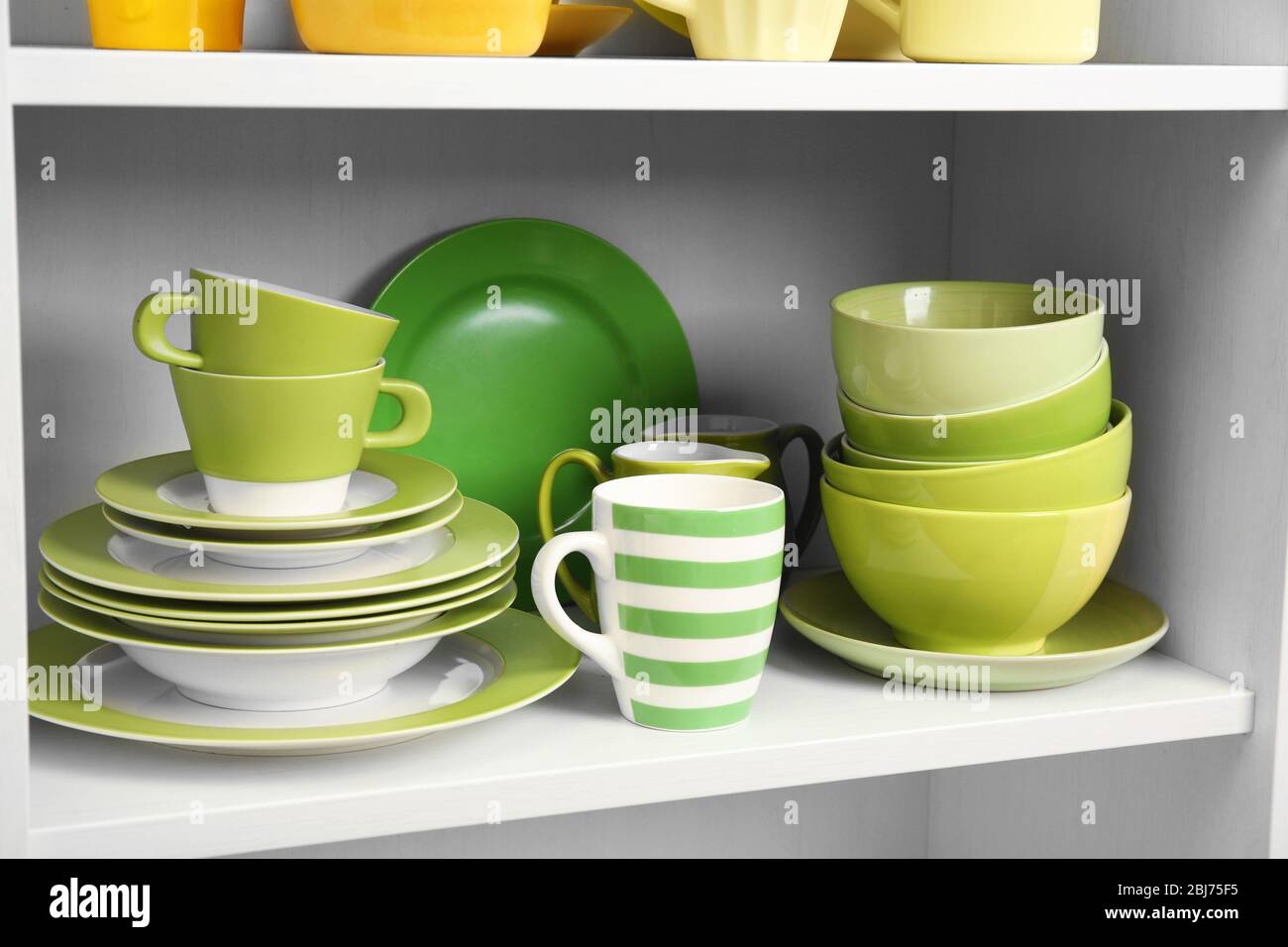 Tableware on shelf in the kitchen cupboard Stock Photo - Alamy