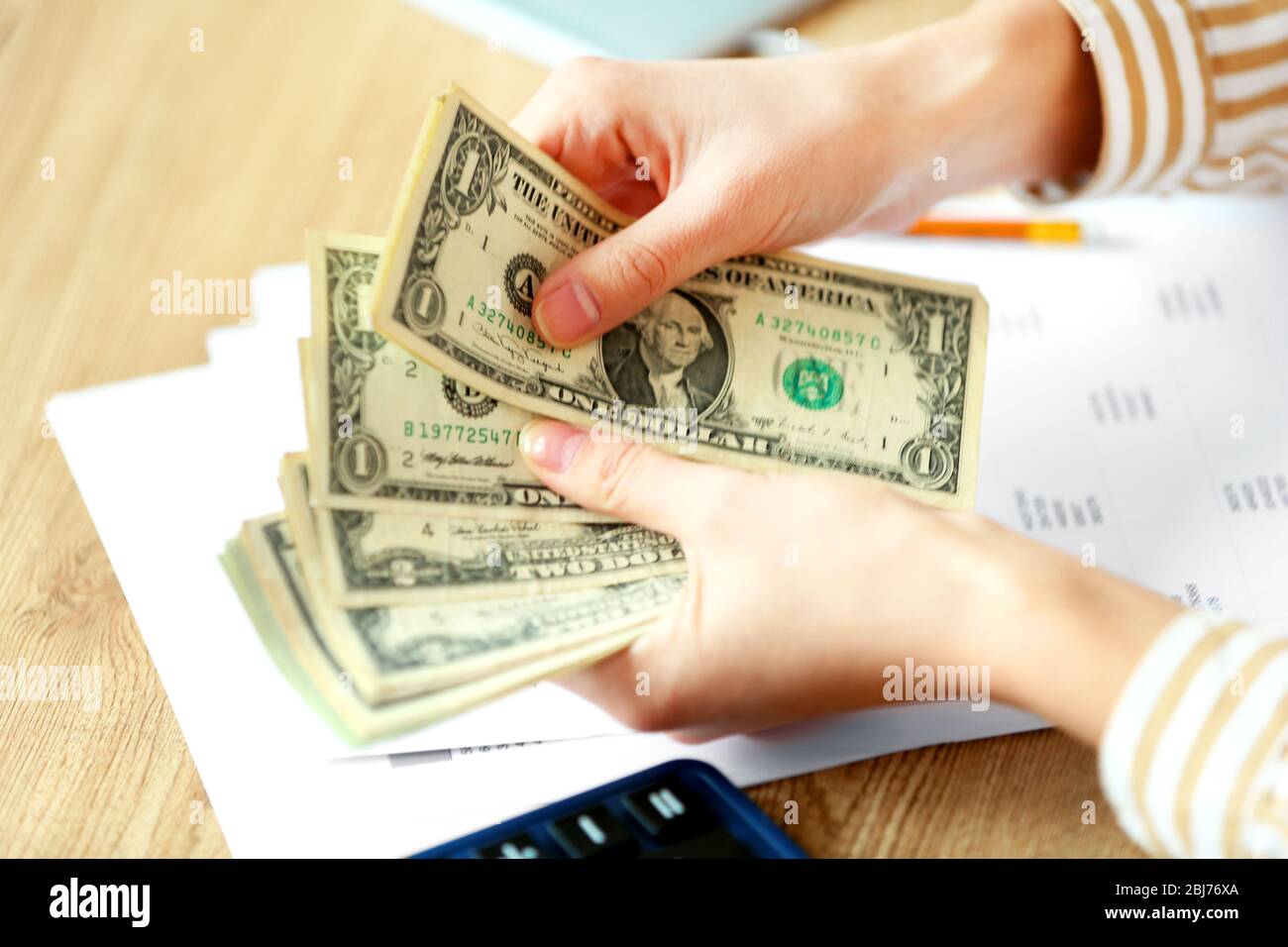 Woman counting money at the table Stock Photo - Alamy