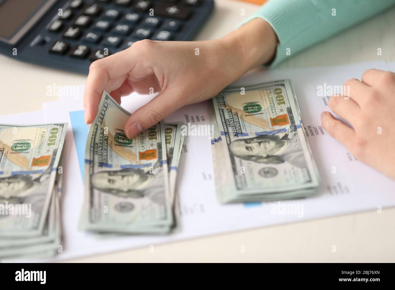 Woman counting money at the table Stock Photo - Alamy