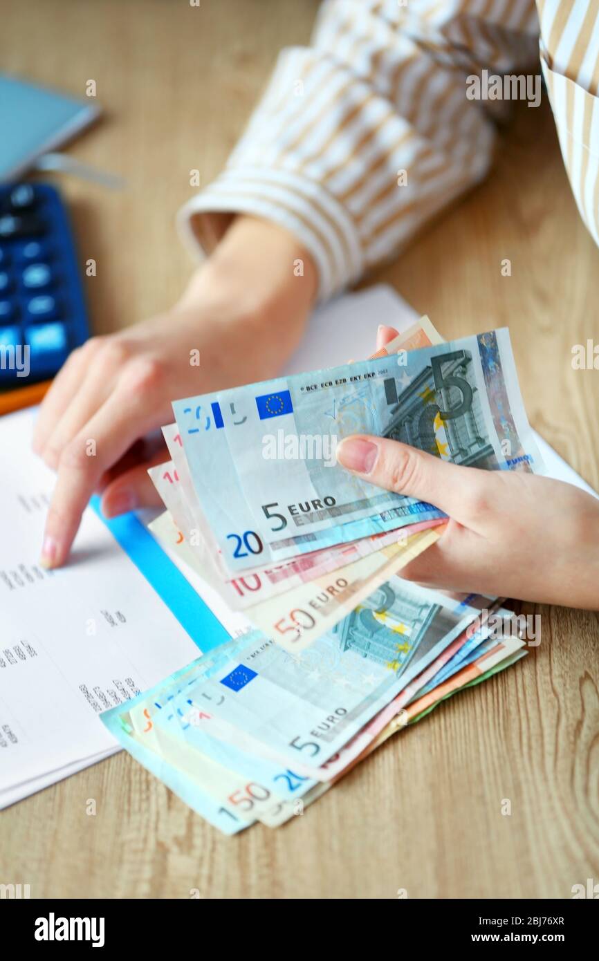 Woman counting money at the table Stock Photo - Alamy