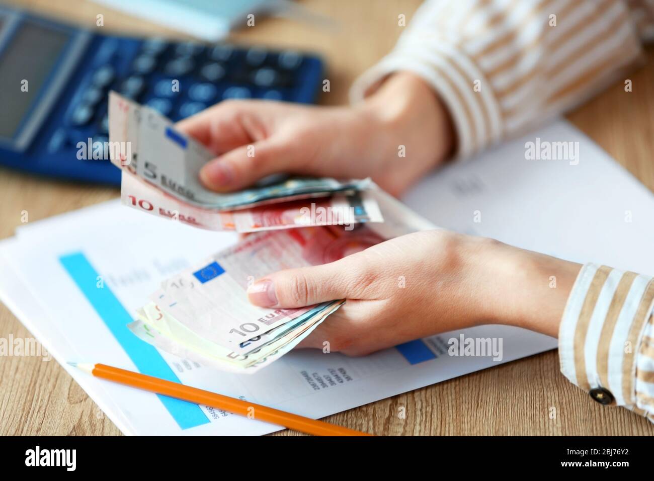 Woman counting money at the table Stock Photo - Alamy