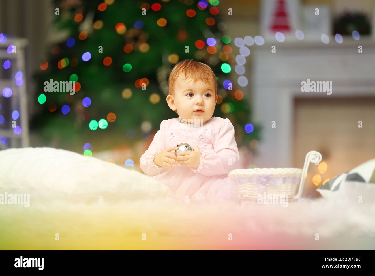 Sweet baby girl with jingle bell on Christmas background Stock Photo ...