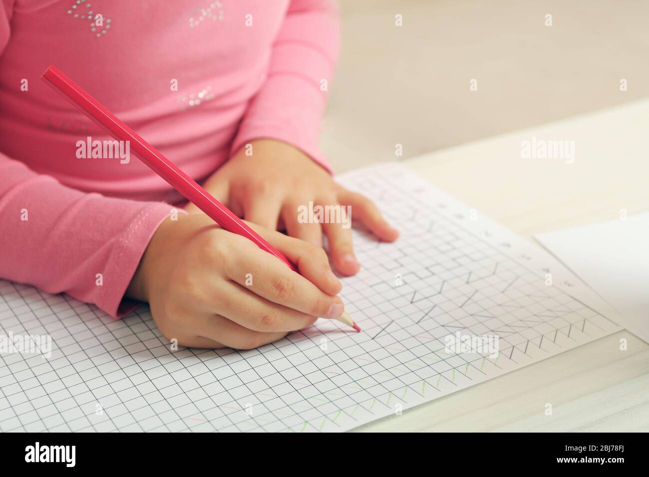 Child drawing with red pencil on paper, closeup Stock Photo - Alamy
