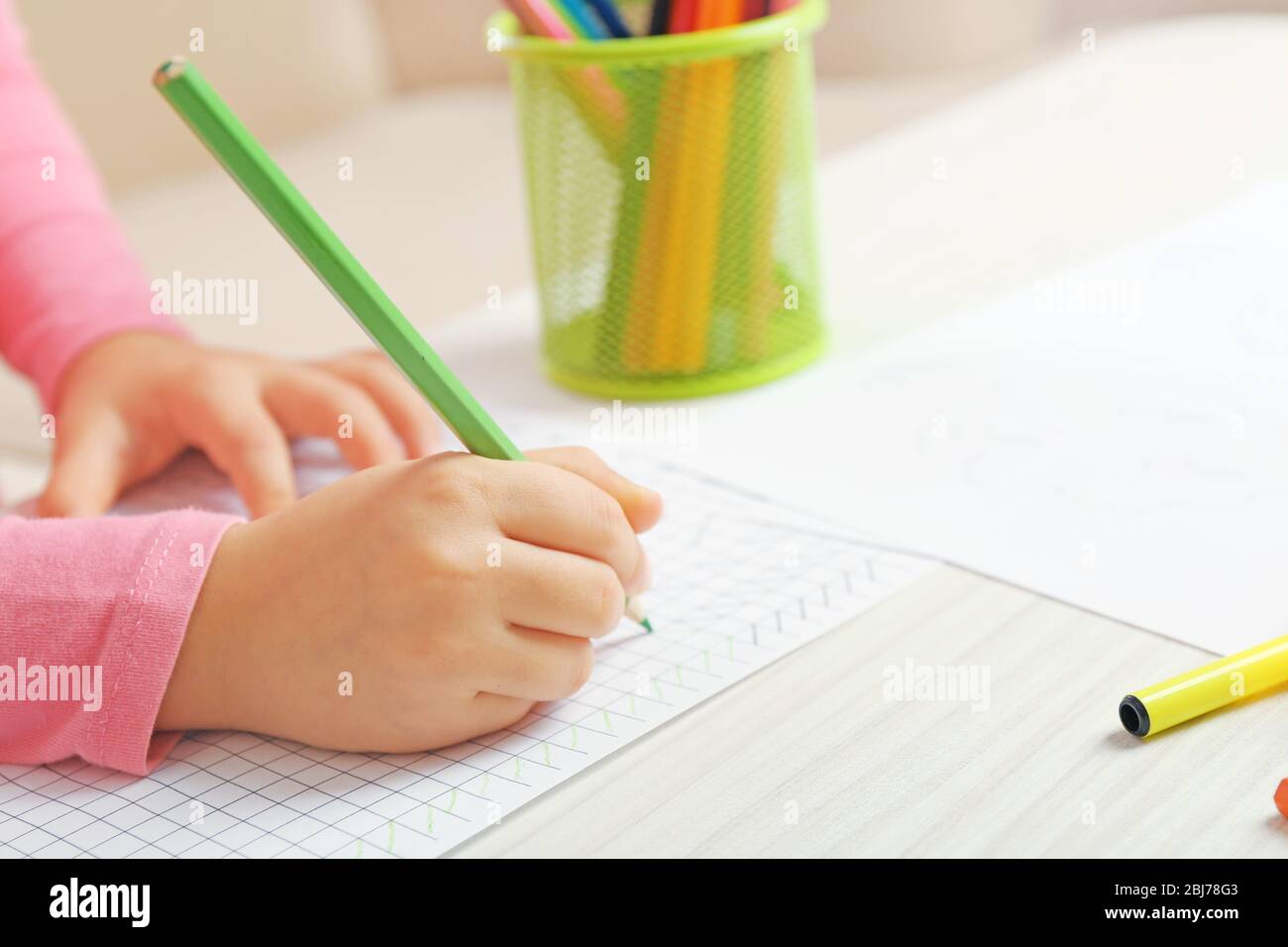 Child drawing with pencils on paper, closeup Stock Photo - Alamy
