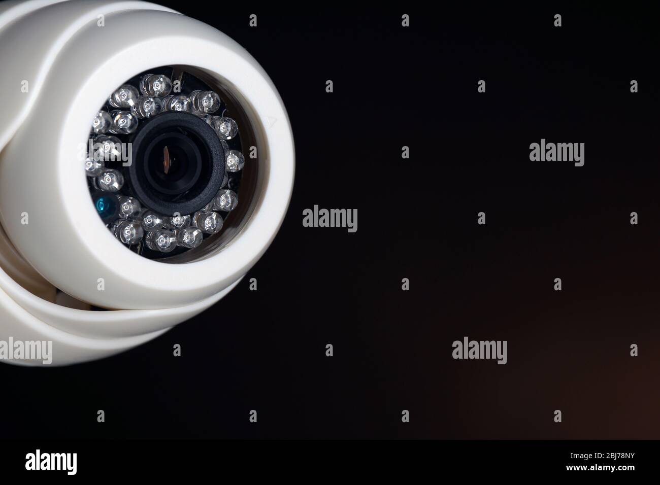 Security CCTV camera on dark yellow background, closeup Stock Photo - Alamy
