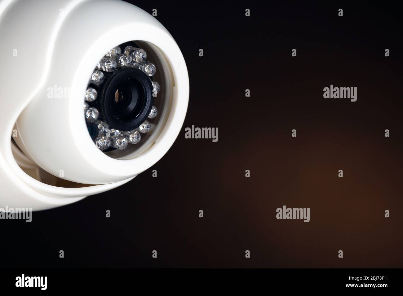 Security CCTV camera on dark yellow background, closeup Stock Photo - Alamy