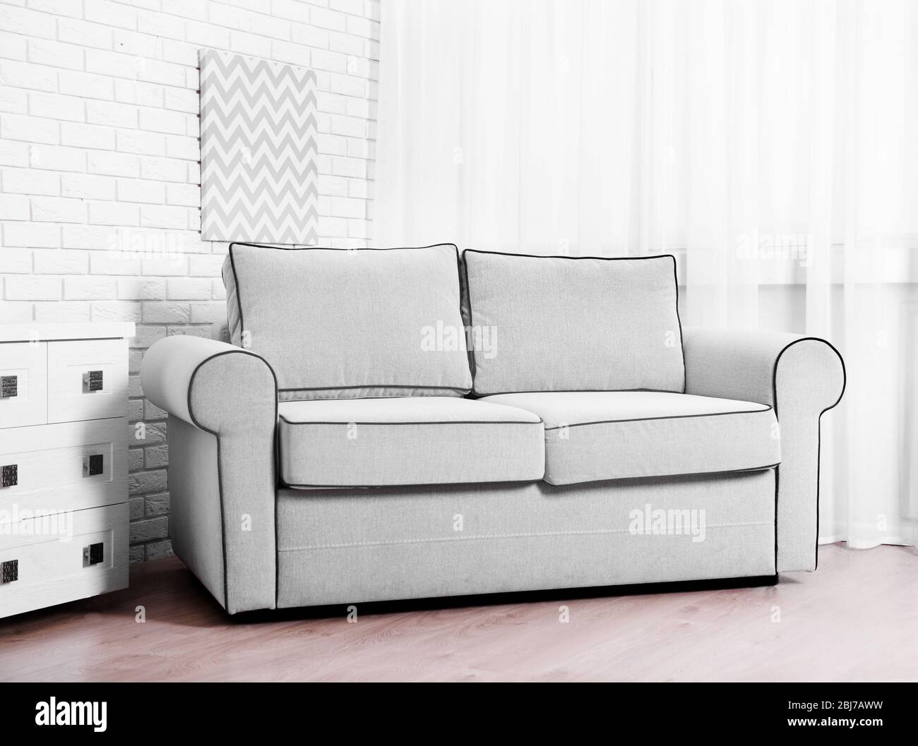 Interior with a modern sofa beside window Stock Photo - Alamy