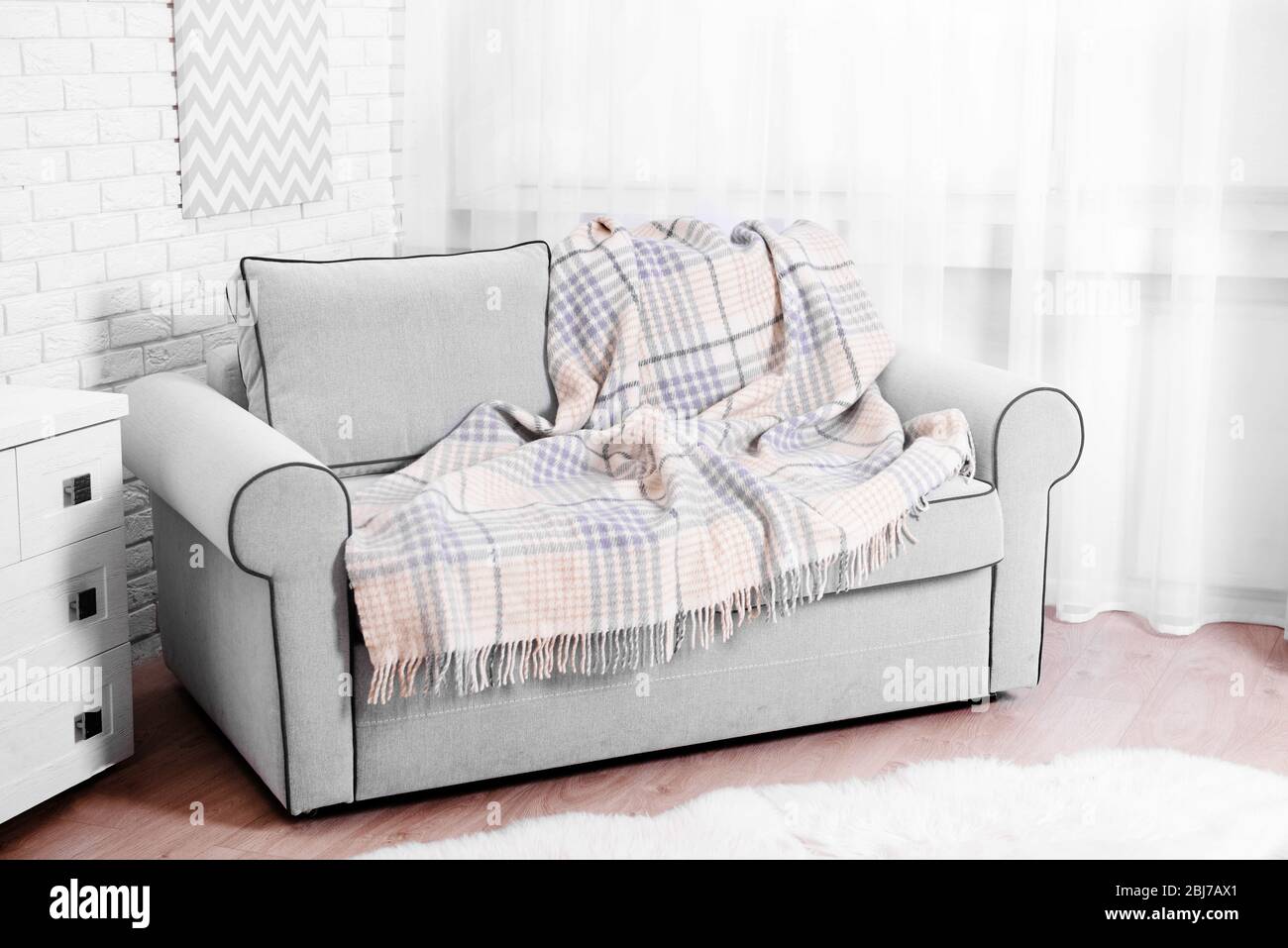 Interior with a modern sofa beside window Stock Photo - Alamy