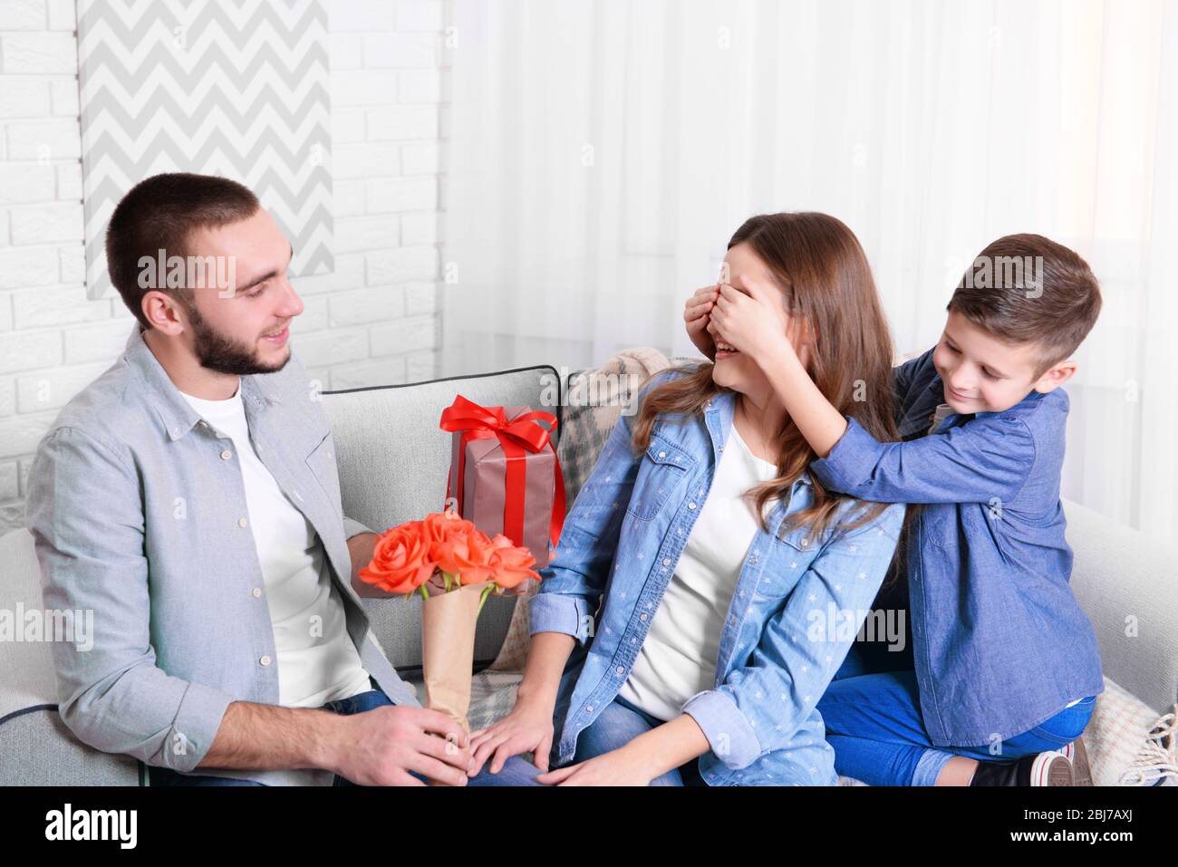 Husband and son giving roses to wife Stock Photo - Alamy
