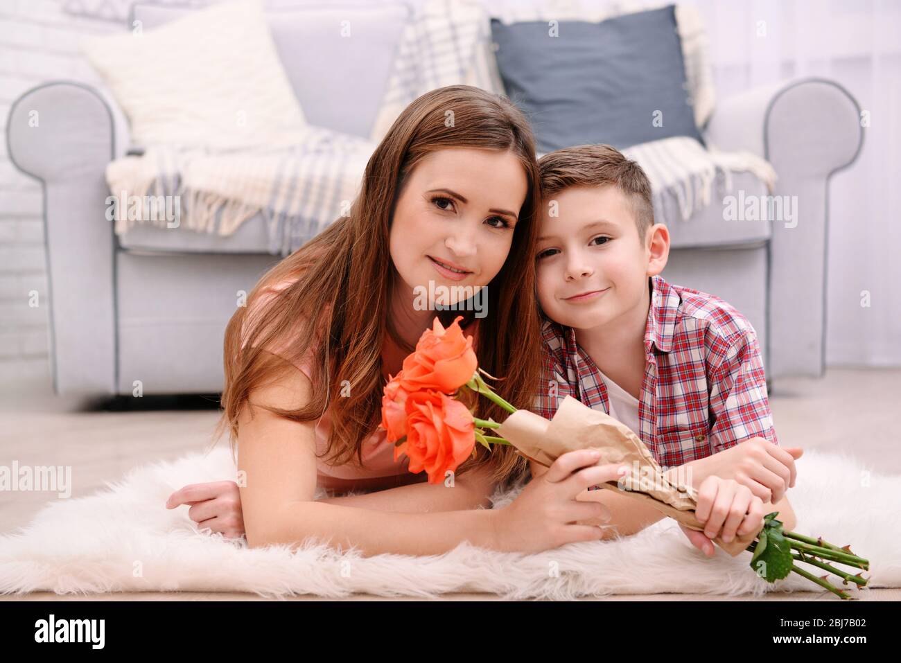 Son giving roses to his mother Stock Photo - Alamy