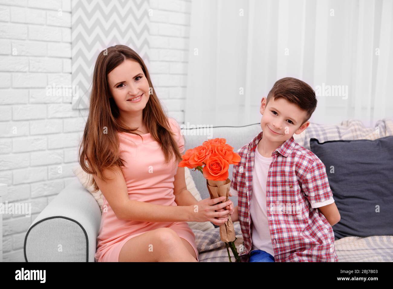 Son giving roses to his mother Stock Photo - Alamy