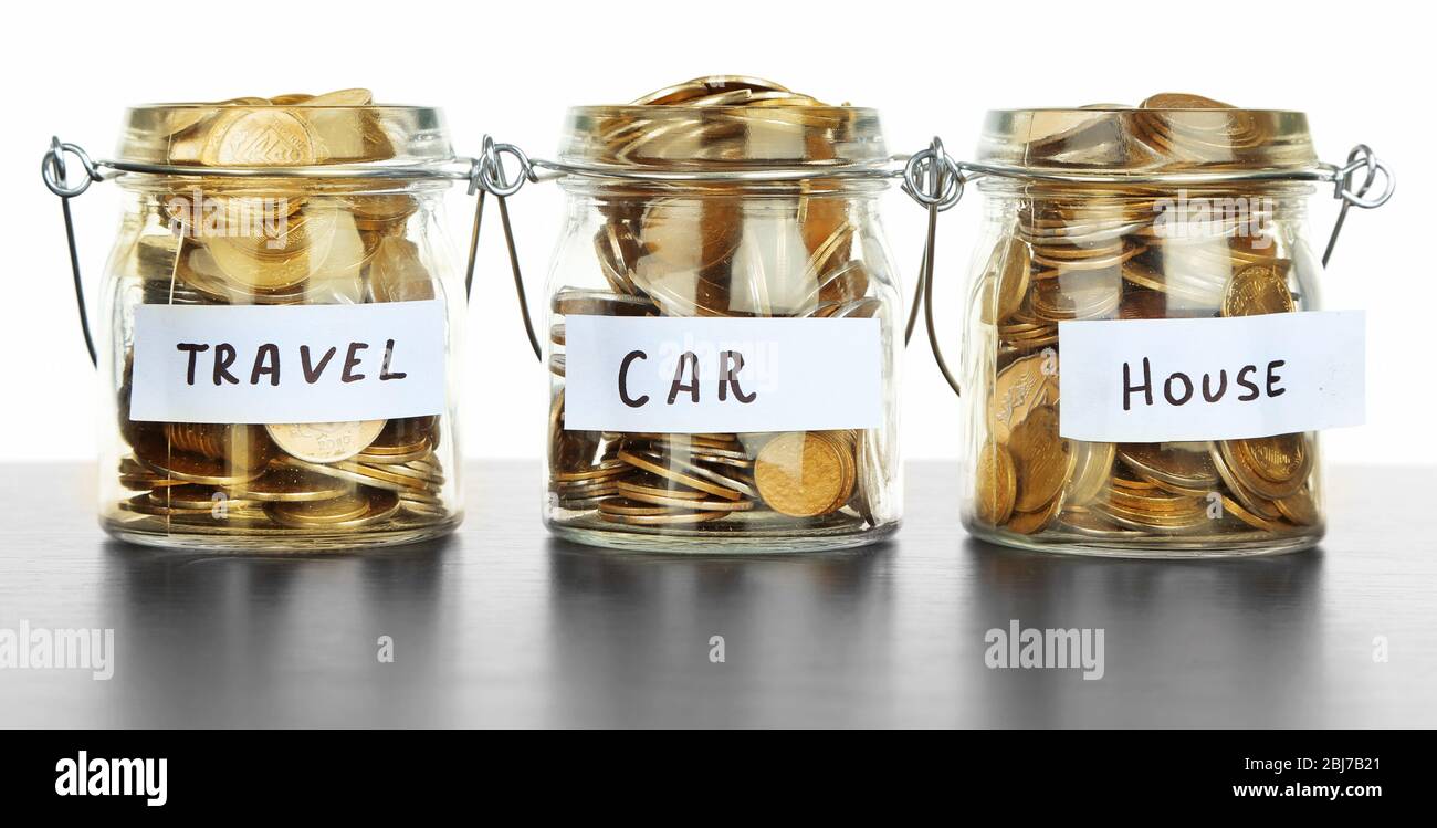 Three jars for different needs full of coins Stock Photo - Alamy