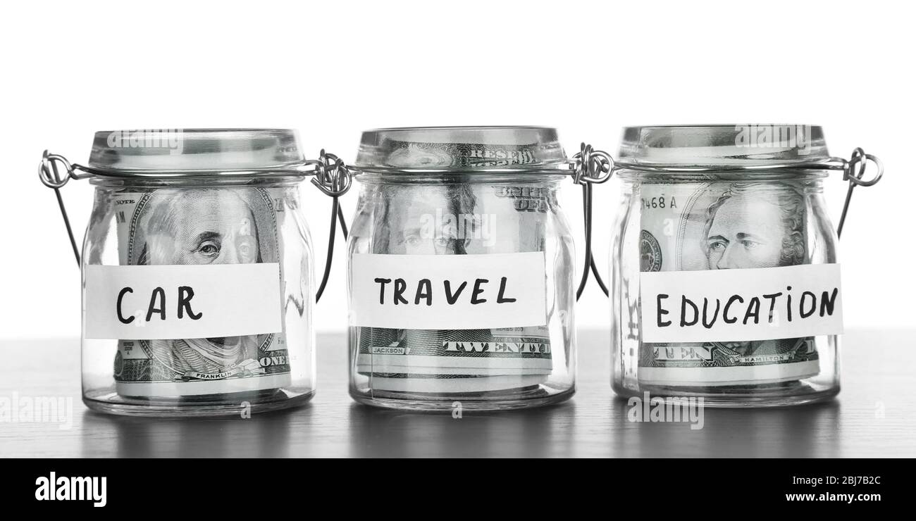 Three jars for different needs full of banknotes Stock Photo - Alamy