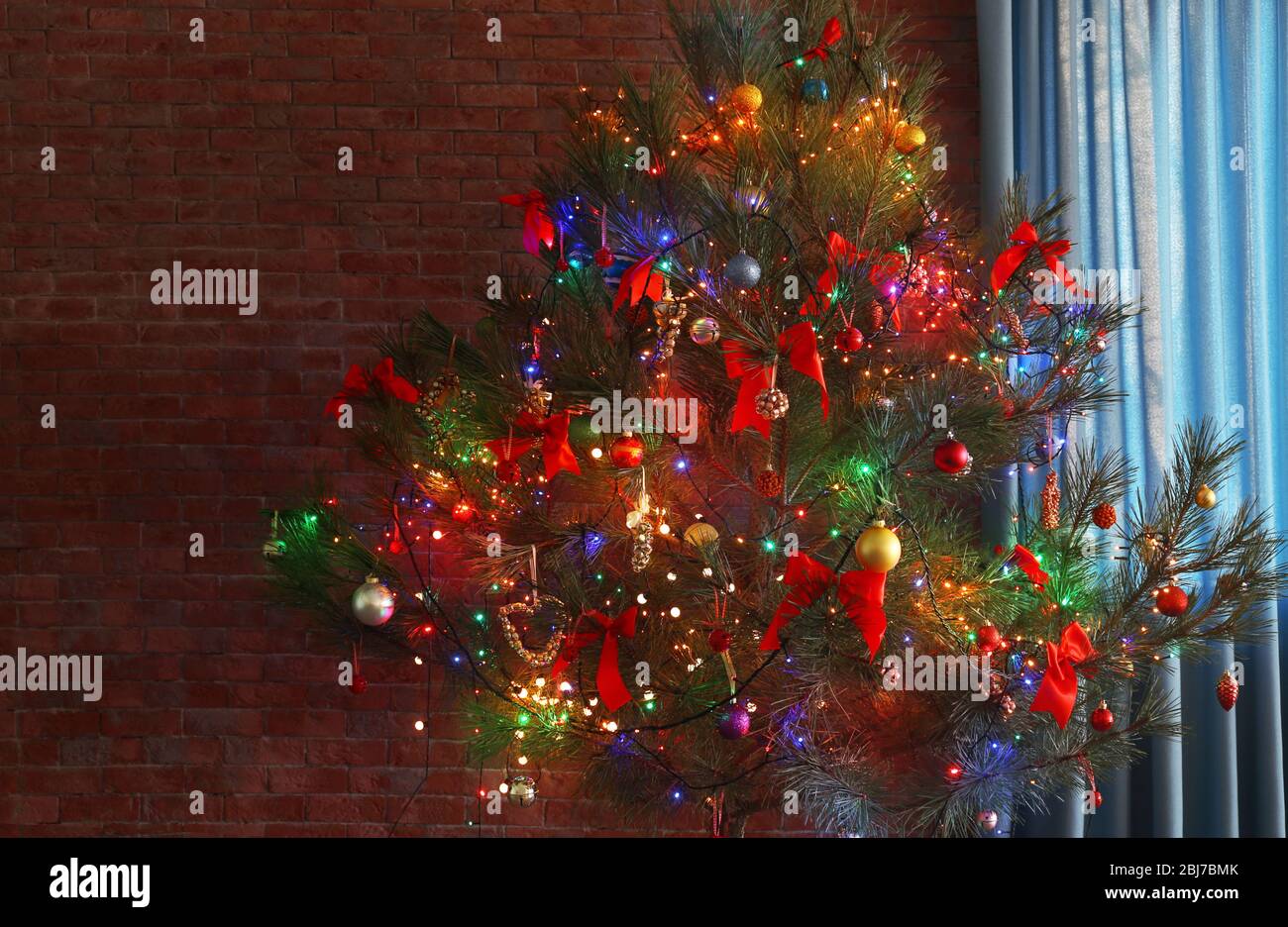 Christmas tree on brick background Stock Photo - Alamy