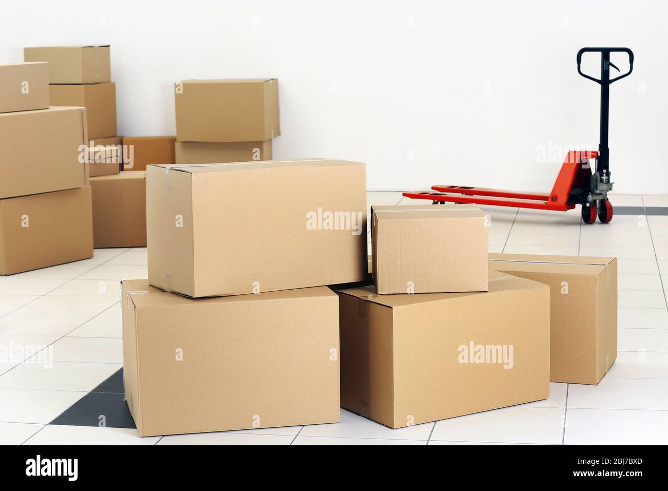 Stack of carton boxes and manual pallet truck indoors Stock Photo - Alamy