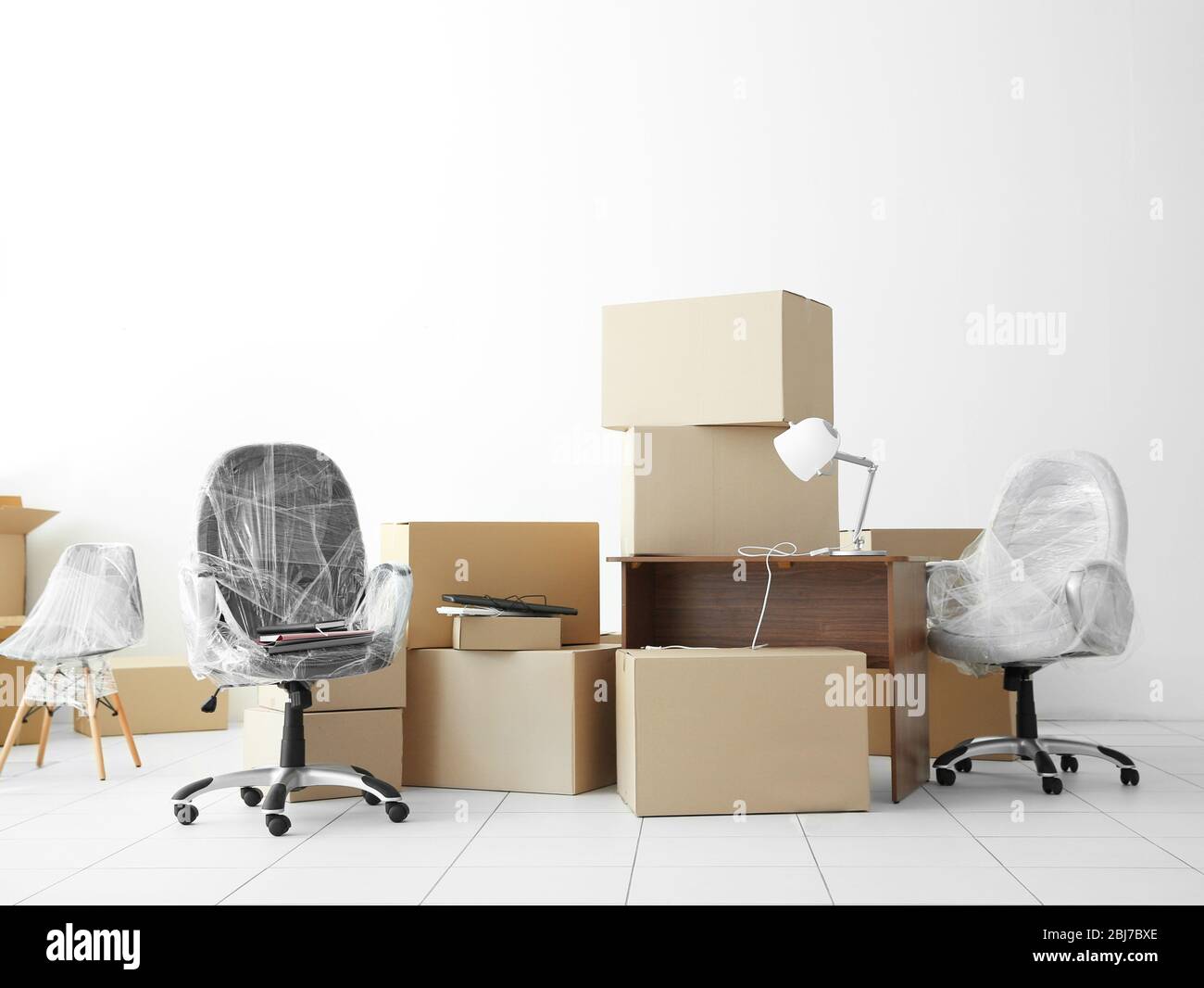 Moving cardboard boxes and personal belongings in empty office space ...