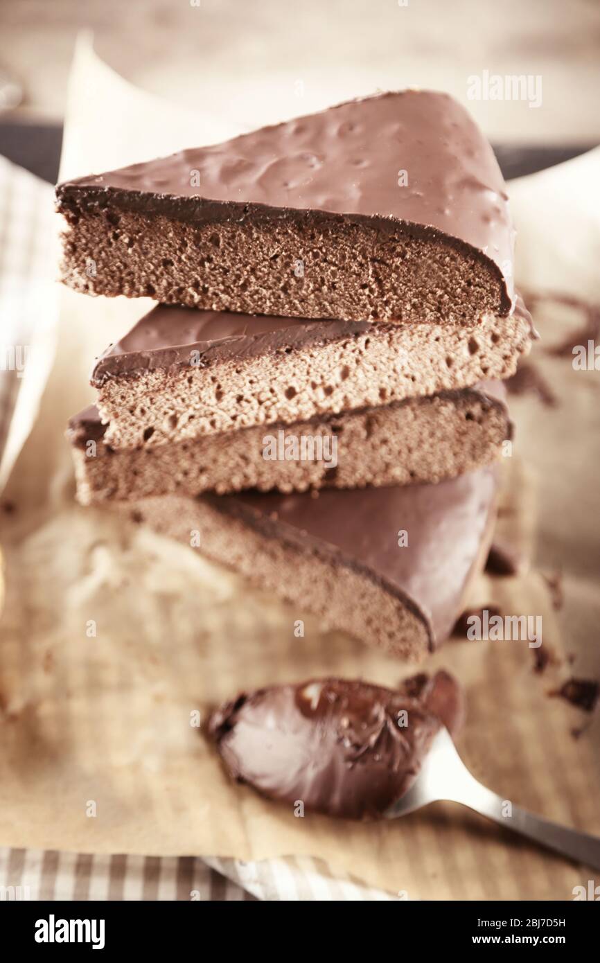 Pieces of frosting chocolate cake on parchment paper Stock Photo - Alamy