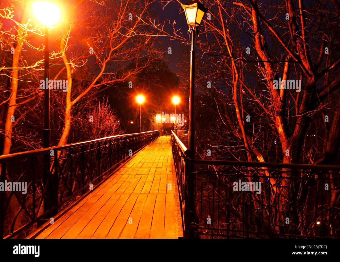 Illuminated street lights and wooden bridge at night Stock Photo - Alamy