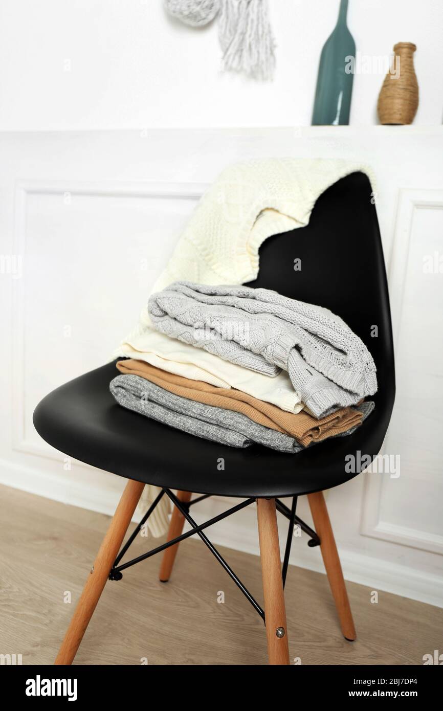 Stack of clothes on black chair over white wall background Stock Photo ...