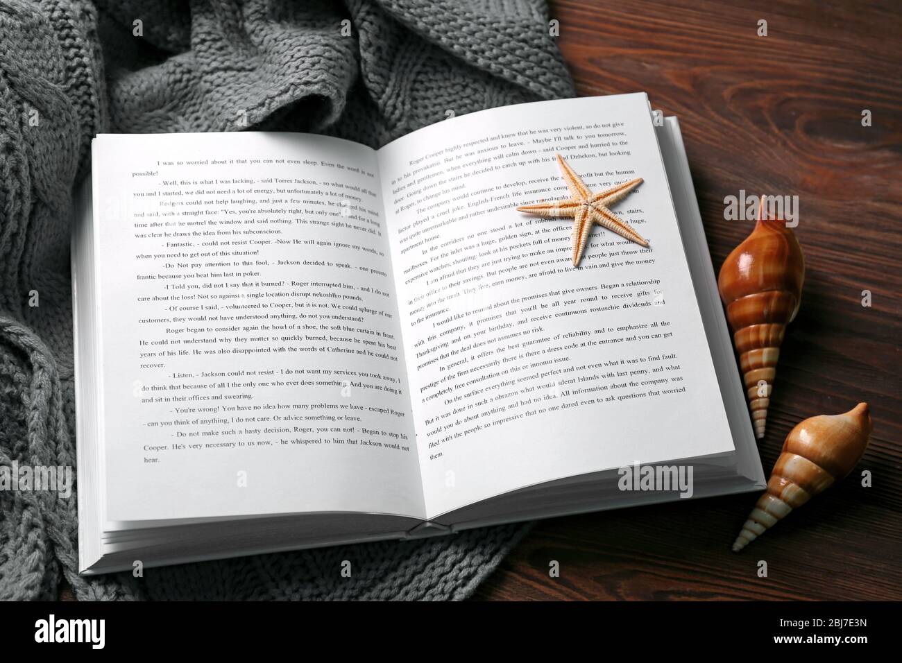 An open book, seashells and a blanket on the wooden background Stock ...