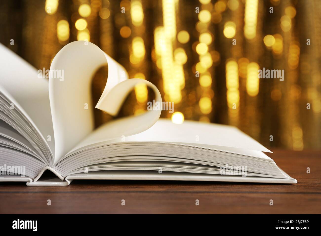 Heart from book pages on glitter background Stock Photo - Alamy