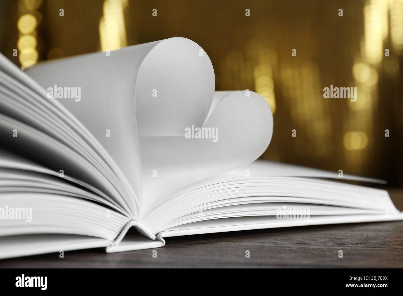 Heart from book pages on glitter background Stock Photo - Alamy